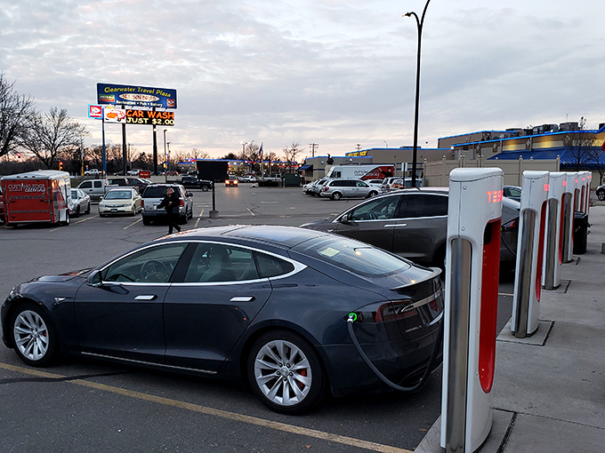 Tesla chargers and classic American fuel pumps coexisting peacefully, like a technological odd couple that actually works.