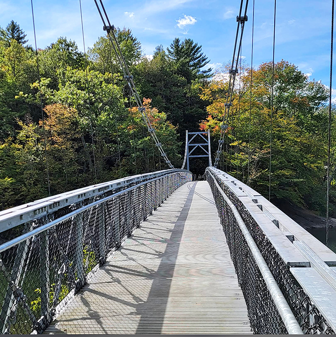 The Winooski Footbridge stretches toward autumn foliage like a runway to nature's fashion show, where every tree is trying to outdo the others in brilliance.