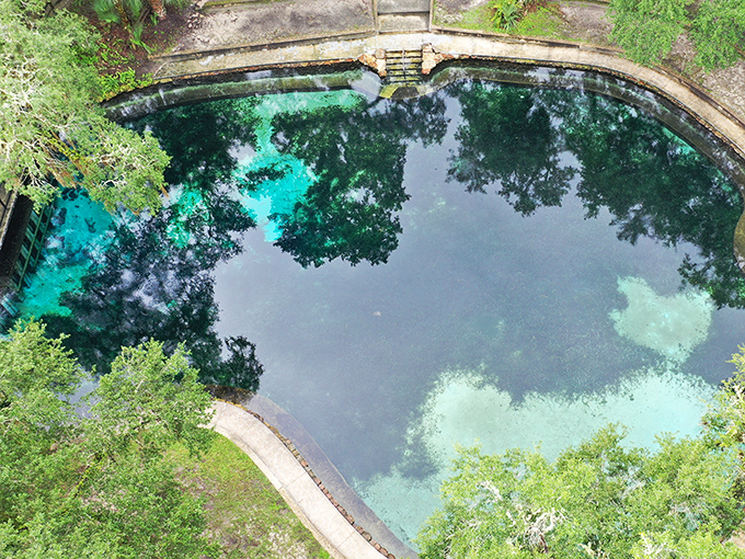 The aerial view reveals the spring's perfect circular form, like a sapphire carefully placed in an emerald setting by a giant jeweler.