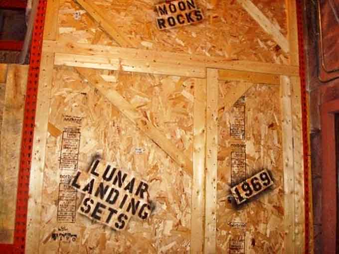 "LUNAR LANDING SETS" stamped on wooden crates playfully nods to moon landing conspiracy theories, adding another layer to the attraction's government cover-up theme.