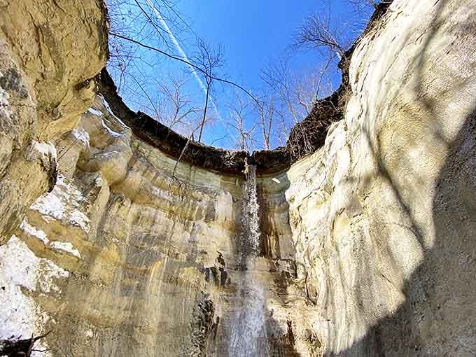 Water trickles down the canyon wall, creating a delicate natural shower that catches sunlight like strings of diamonds.