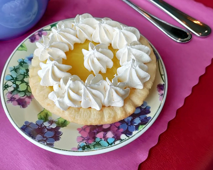 Lemon tart crowned with whipped cream &ndash; sunshine-yellow filling in buttery pastry that strikes the perfect balance between sweet and tart.