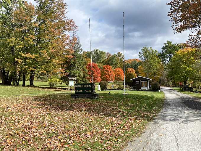 Autumn's grand entrance &ndash; fall foliage frames the park's welcome sign, inviting visitors to explore Vermont at its colorful best.