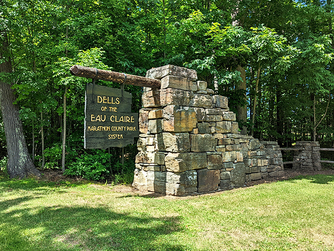 The park's entrance sign stands against a backdrop of stone pillars, a humble introduction to the geological wonders waiting just beyond.