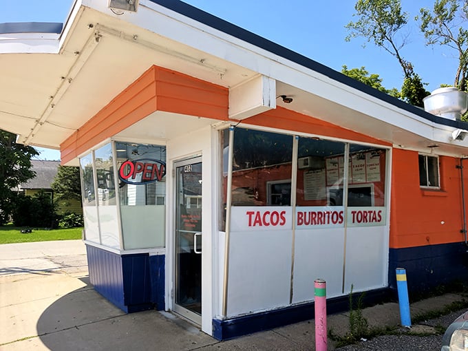 Sunlight bathes the simple storefront, highlighting the "TACOS BURRITOS TORTAS" promise that draws food lovers from near and far.