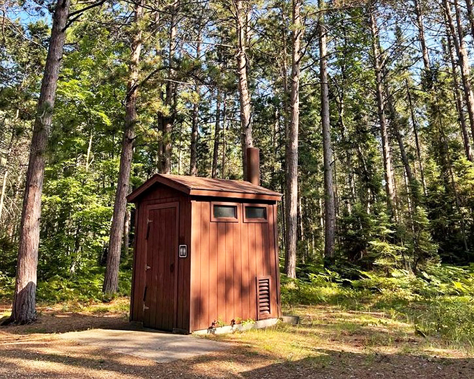This rustic outhouse stands ready for nature's call, proving that even bathroom breaks come with wilderness charm in Michigan's most beautiful state park.