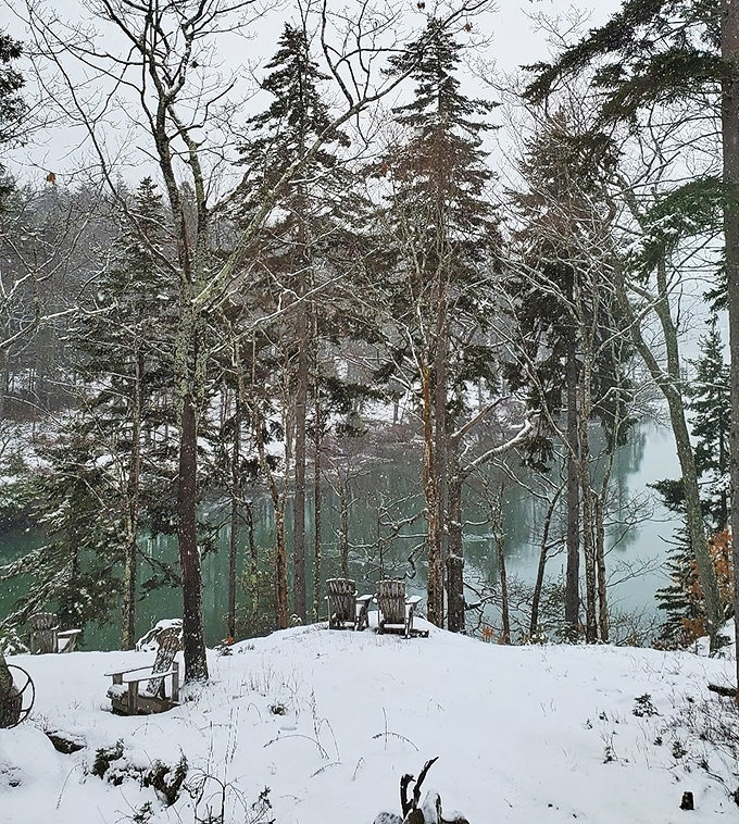 Winter transforms Phippsburg into a snow globe scene, where Adirondack chairs wait patiently for warmer days by the frozen shore.