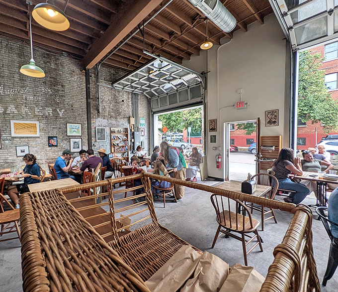 Sunlight streams through garage-style windows at August First, where wooden chairs and exposed brick create the perfect setting for pie indulgence.