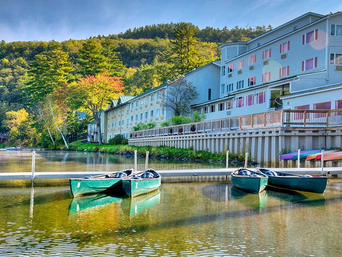 Lake Morey Resort: A grand white structure rising from Vermont's landscape, where turquoise canoes wait patiently on glassy waters for their next adventure.