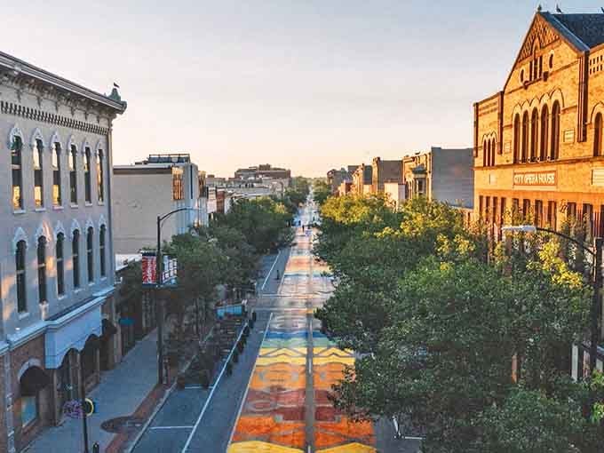 Alpena's charming downtown stretches invitingly under blue skies, historic buildings lining both sides of the street.