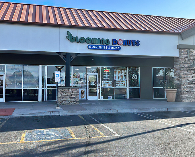 Blooming Donuts welcomes sweet-toothed visitors with its cheerful green and blue signage, promising a paradise of pastries inside.