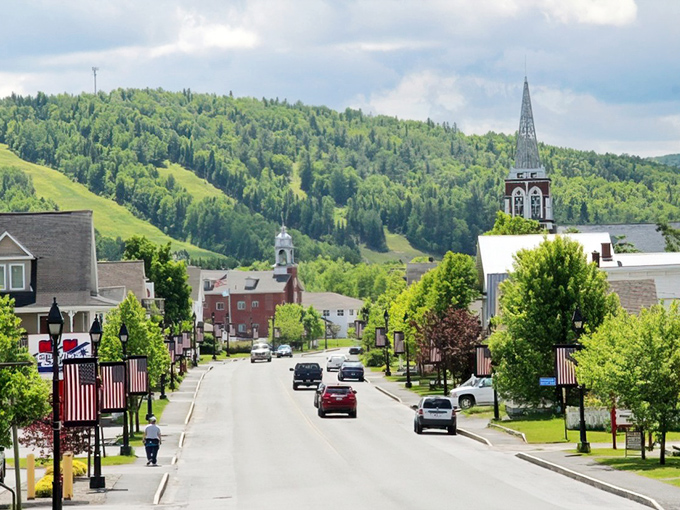 Fort Kent's charming main street welcomes travelers with tree-lined roads and mountain views. The perfect starting point for any Maine adventure!