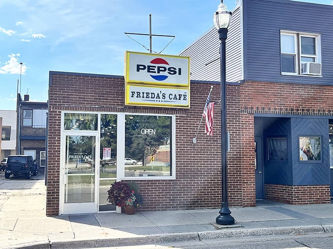 Frieda's Cafe welcomes hungry travelers with its classic brick exterior and vintage Pepsi sign &ndash; a true small-town breakfast institution.
