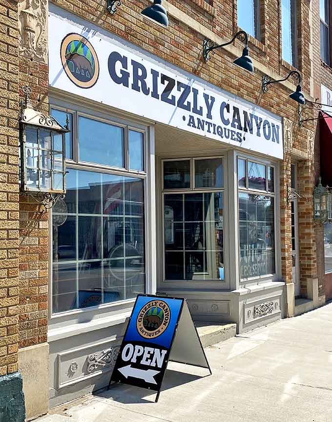 The welcoming storefront of Grizzly Canyon Antiques invites treasure hunters with its classic brick facade and vintage-inspired signage.
