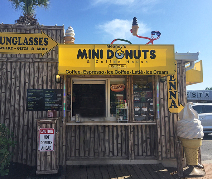 Meaney's wooden shack stands out with its giant ice cream cone statue and bright yellow "Mini Donuts" sign. Beach vibes and sugar highs await!