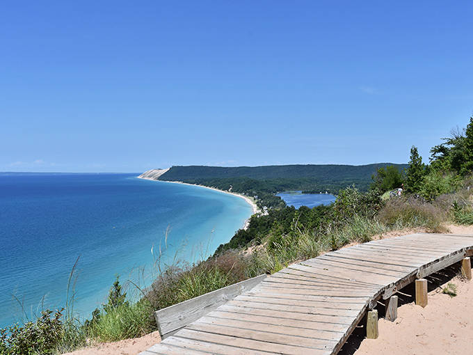 Sleeping Bear Dunes offers this jaw-dropping view where turquoise waters meet golden shores. The wooden walkway invites you to pause and soak in Michigan's coastal majesty.