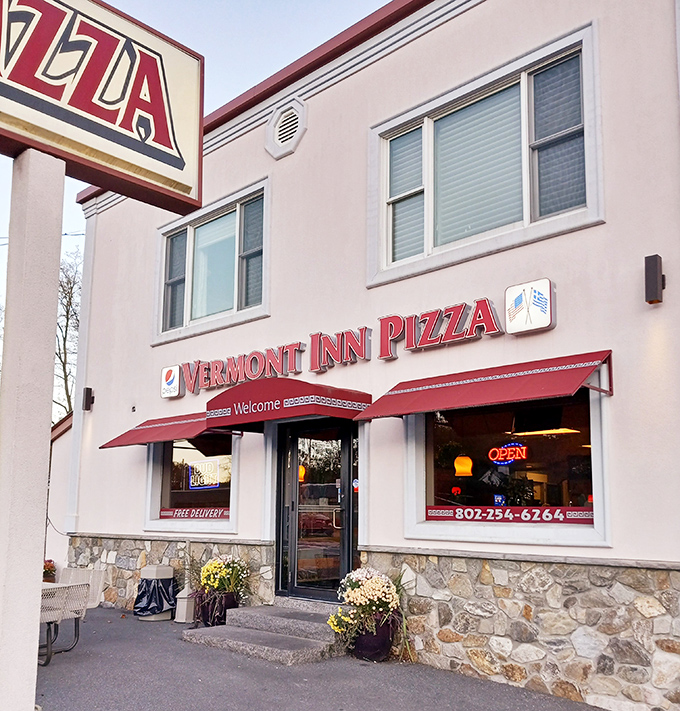 Vermont Inn Pizza's welcoming storefront with its classic red awnings invites pizza lovers to step inside for a slice of local flavor.