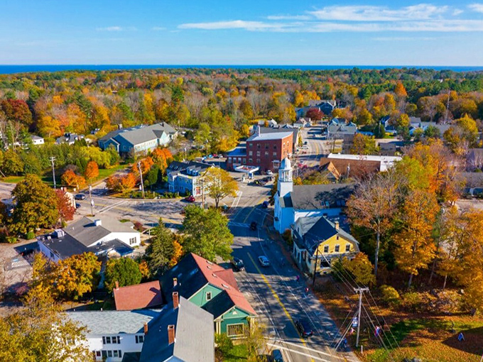 York's charming downtown unfolds beneath autumn's fiery display, with the white church steeple standing tall like the town's exclamation point.