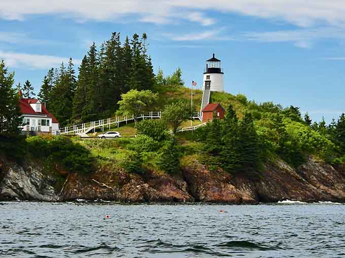The view from the water shows why filmmakers fell in love with this lighthouse and its dramatic coastal setting.