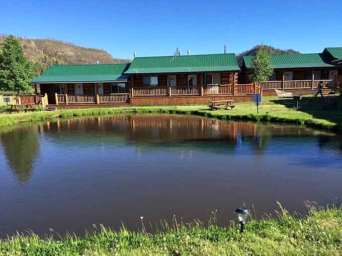 Lakeside lodges mirror perfectly in still waters where mountain peace becomes your daily routine.