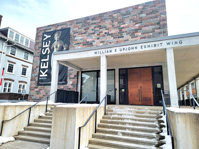 The modern exhibit wing of the Kelsey Museum offers a striking contrast to the historic castle structure, welcoming visitors to explore ancient treasures within.