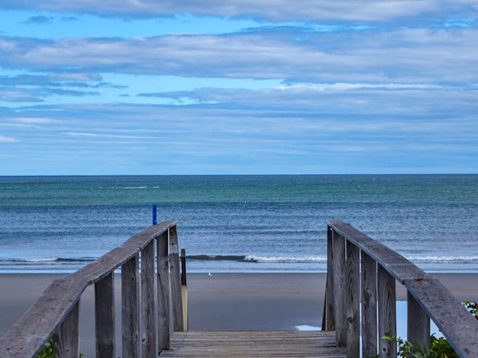 A wooden walkway invites you to step into postcard perfection at Laudholm Beach, where the horizon seems endless.