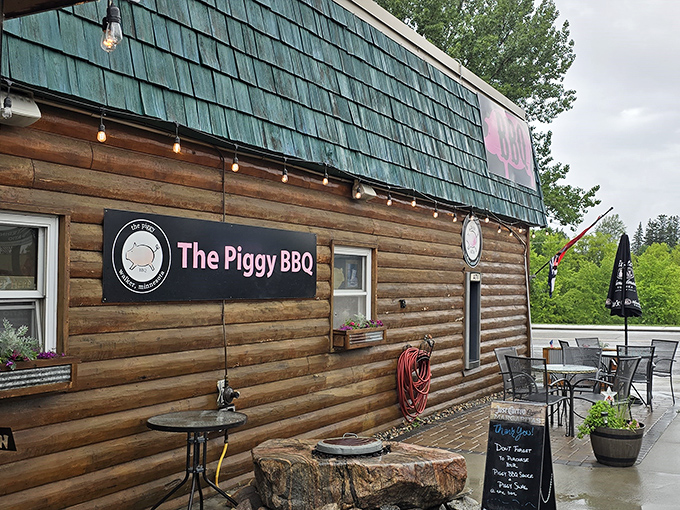 A close-up of The Piggy BBQ's wooden facade showcases their signature sign and cozy outdoor seating area &ndash; the perfect spot to enjoy fall-off-the-bone ribs in Walker's fresh air.