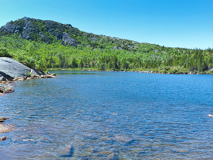 Tumbledown Pond glistens like a sapphire jewel nestled among rocky mountain peaks, rewarding hikers with crystal-clear waters and breathtaking views.
