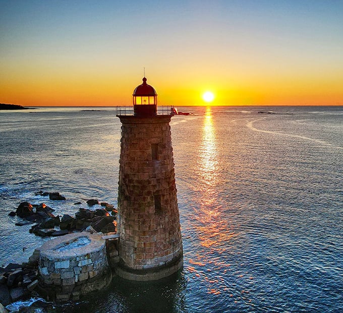 Golden sunset light transforms Whaleback's weathered stone into a glowing beacon, creating a magical moment where sea meets sky.