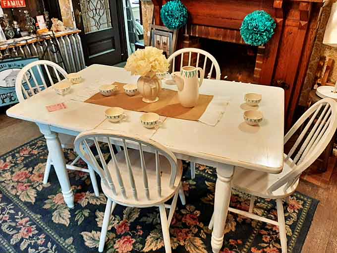 A charming farmhouse dining set awaits its next family gathering, with Windsor chairs and delicate teacups ready for conversation.