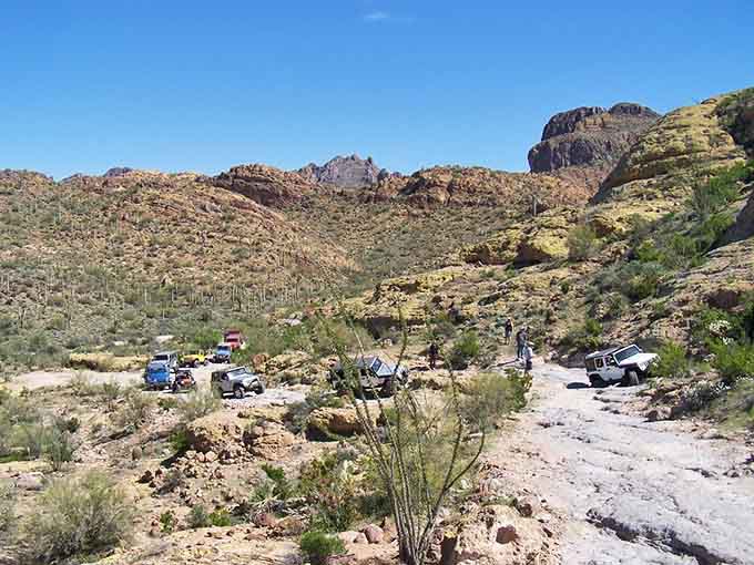 Off-road vehicles gather near the ovens, their modern engineering a stark contrast to the 19th-century craftsmanship towering above them.