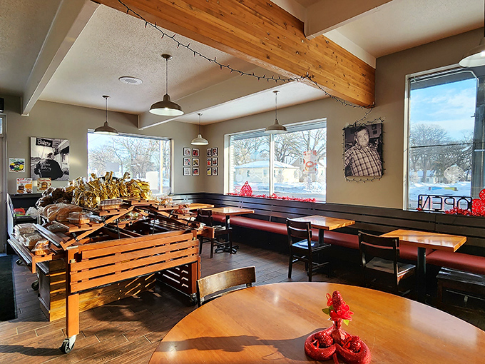 Exposed beams and red booth seating create the perfect stage for your pastry drama, where wooden tables witness daily donut decisions of epic proportions.