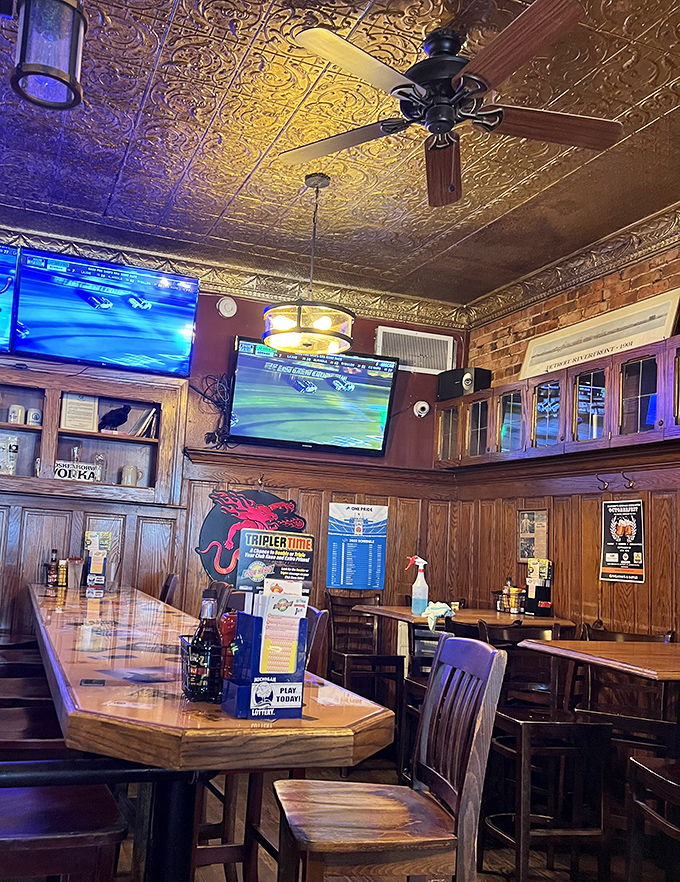 Pressed tin ceilings gleam above wood-paneled walls, creating the perfect backdrop for cold beers and warm conversations since 1904.