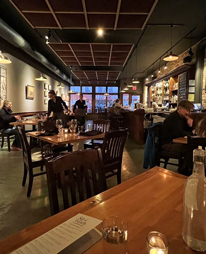Intimate lighting casts a warm glow over wooden tables and exposed brick, creating the perfect backdrop for memorable Michigan meals.