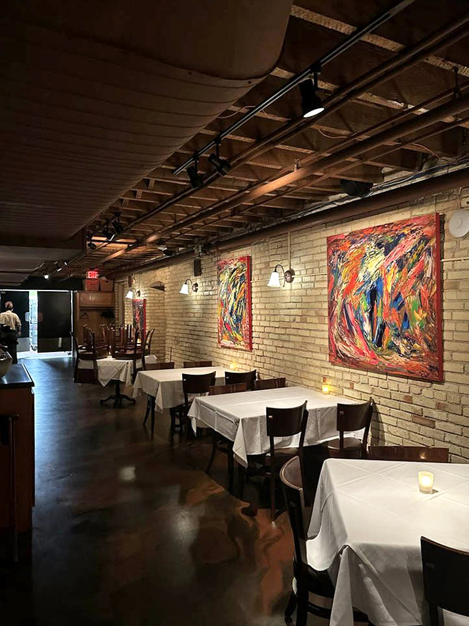 Exposed brick walls and vibrant artwork create a dining space where history and contemporary cuisine dance together in perfect harmony.
