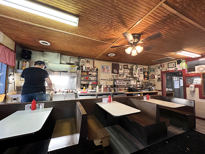 Step inside to wooden booths worn smooth by generations of diners, where the amber glow from wood-paneled ceilings creates warmth no filter could capture.