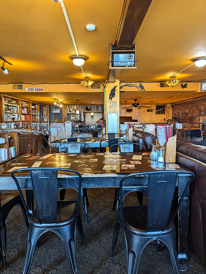Warm golden ceilings hover above a bibliophile's paradise, where metal chairs and wooden tables invite you to linger among thousands of books.