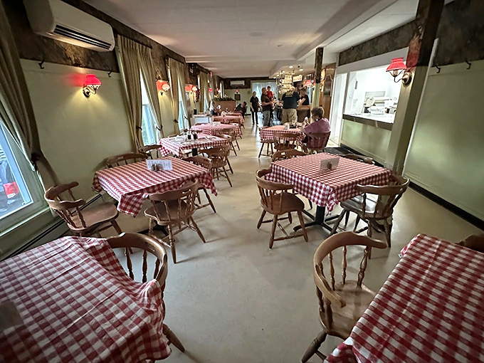 Interior: Red and white checkered tablecloths transport diners to simpler times, where conversations flow as freely as the exceptional pizza being served.