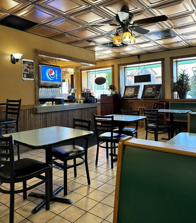 Step inside to a cozy dining area where the ornate ceiling tiles and warm lighting create the perfect backdrop for comfort food indulgence.