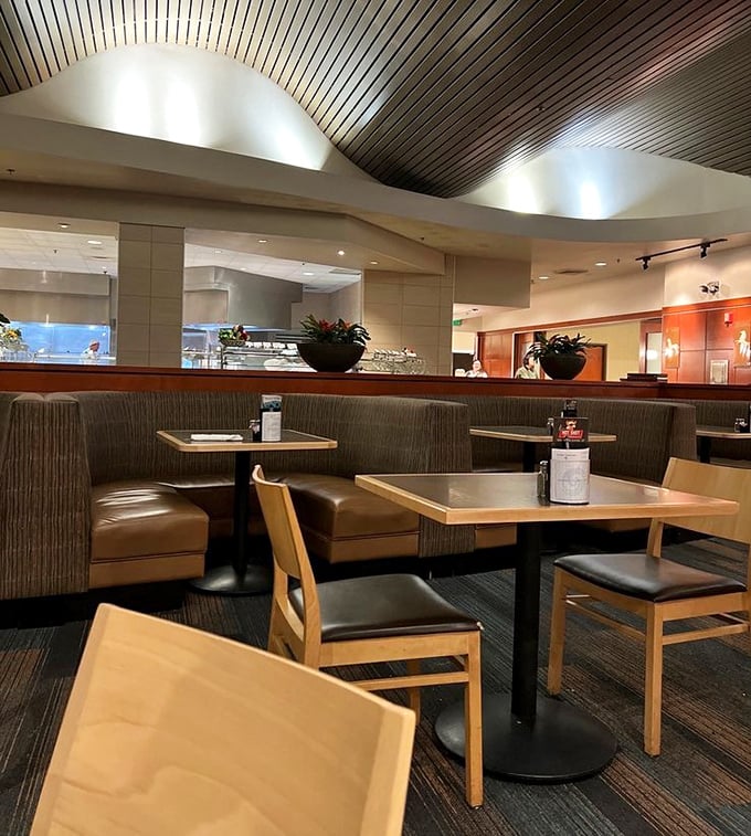 Elegant curved ceiling panels and cozy booth seating create an inviting atmosphere that encourages lingering over multiple plates of deliciousness.