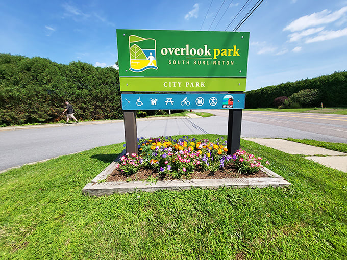 The cheerful park sign stands amid vibrant flowers, a colorful gateway to South Burlington's scenic treasure.