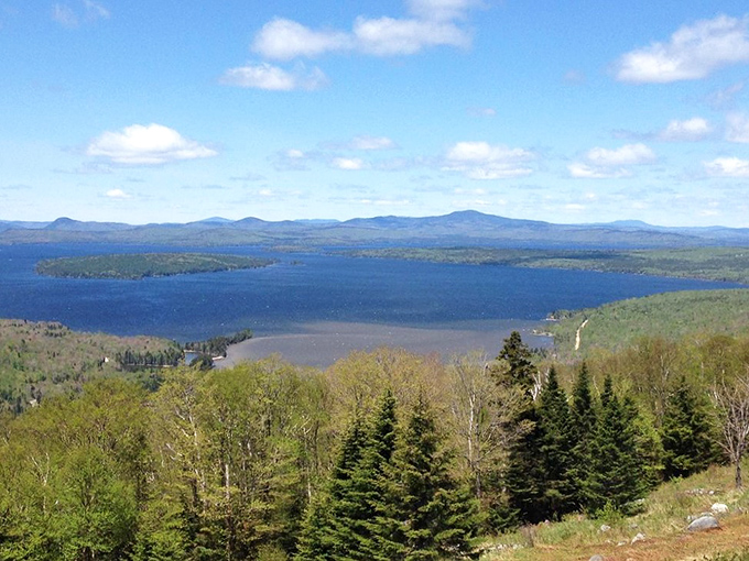 From this sweeping vantage point, Rangeley Lake stretches toward the horizon like a sapphire nestled among emerald mountains &ndash; Maine's crown jewel on full display.