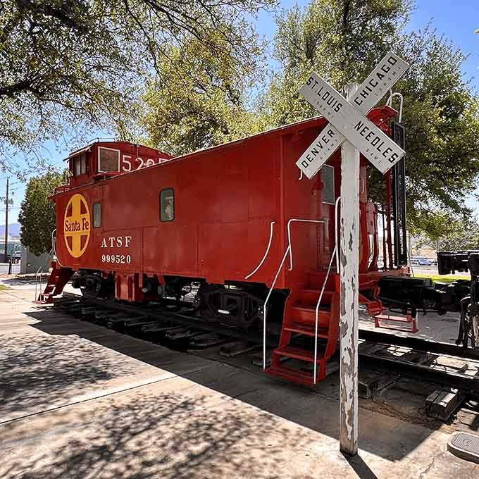 That classic Santa Fe caboose sits proudly on display, a bright red reminder of railroading's colorful past.