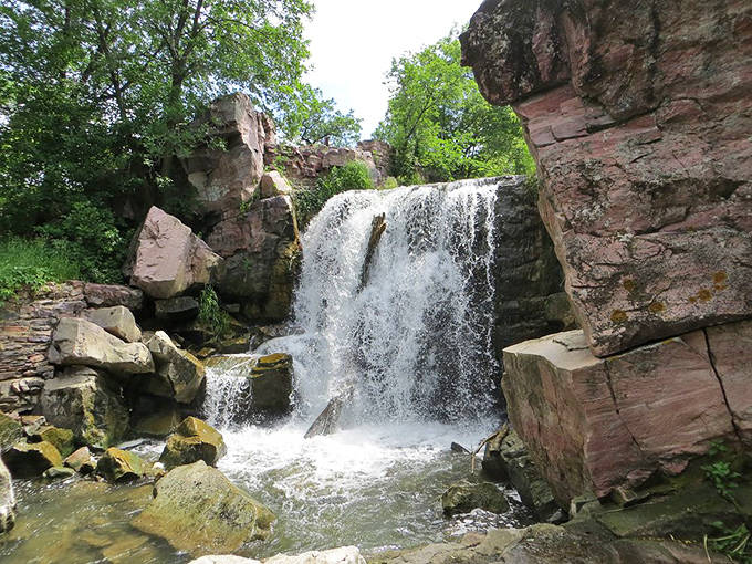 Winnewissa Falls cascades gracefully between rugged rock walls, offering a peaceful soundtrack to your journey through sacred grounds.