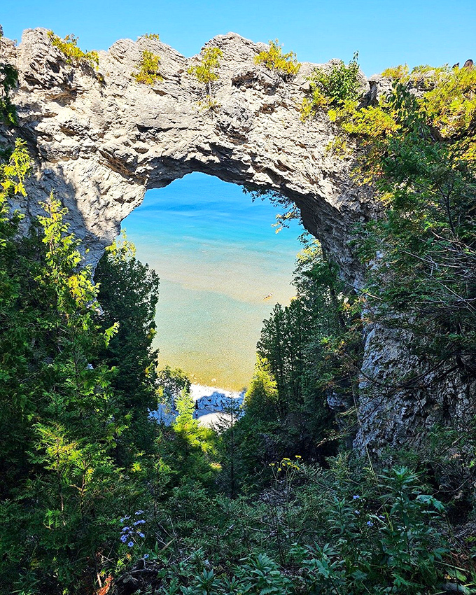 The limestone arch stands like a gateway to another world, with layers of geological history telling a 4,000-year-old story in stone.