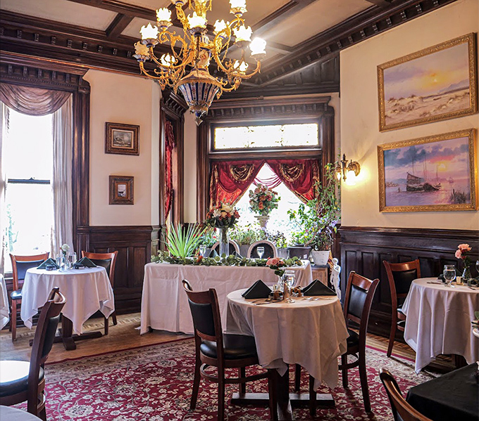 The dining room exudes Victorian elegance with its rich wood paneling, crystal chandelier, and white tablecloths &ndash; dinner with a side of time travel.