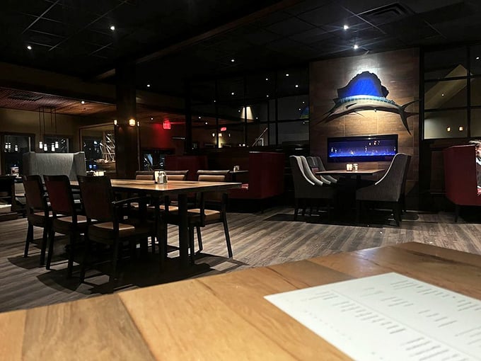 Warm wood tones and nautical-inspired d&eacute;cor create an intimate dining atmosphere, with a sailfish silhouette watching over happy diners.