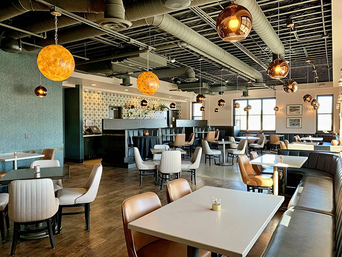 Warm amber pendant lights create an inviting atmosphere where contemporary design meets historic charm in this unique dining space.