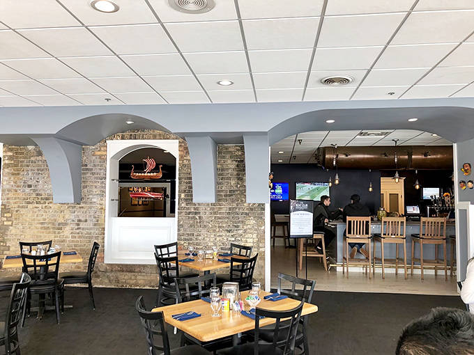 Exposed brick arches frame the dining room, creating intimate spaces where nautical charm meets contemporary comfort.