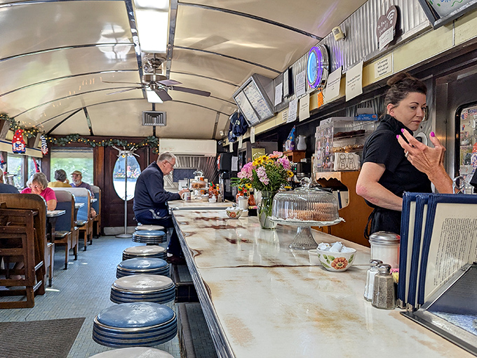 Inside, the classic diner counter invites solo diners to perch on swiveling stools while watching the kitchen magic unfold just feet away.